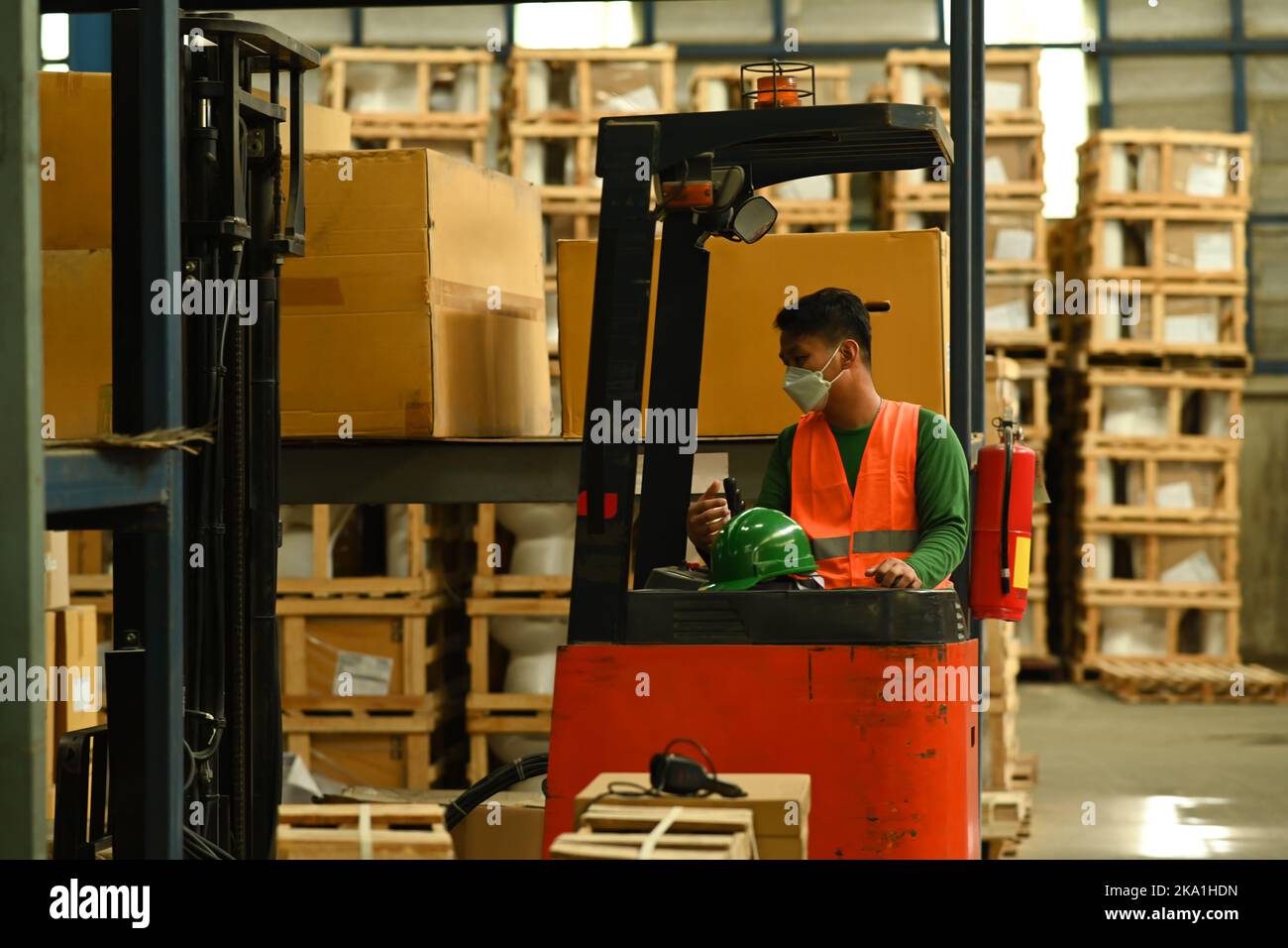 Un ouvrier d'entrepôt déplace des boîtes en carton de marchandises avec ...