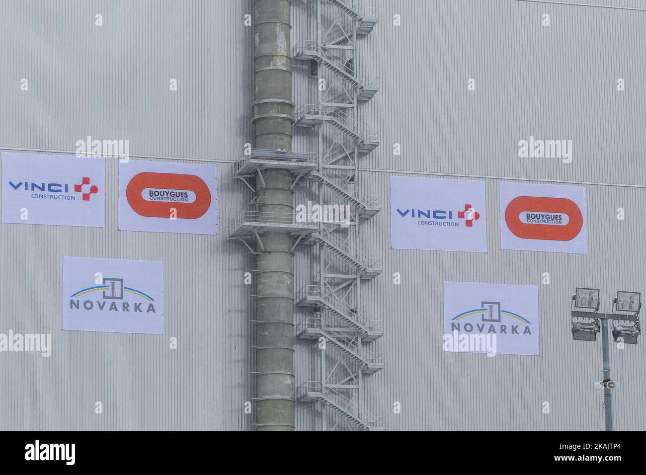 Le travailleur de 'Novarka' traverse le chantier de construction devant ...