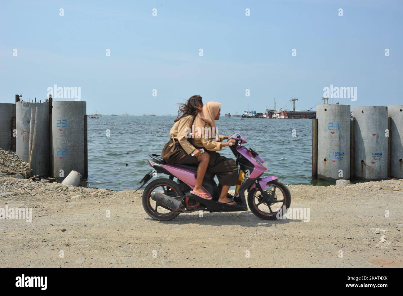 Rider a passé la construction de la digue à Jakarta, en Indonésie, sur ...