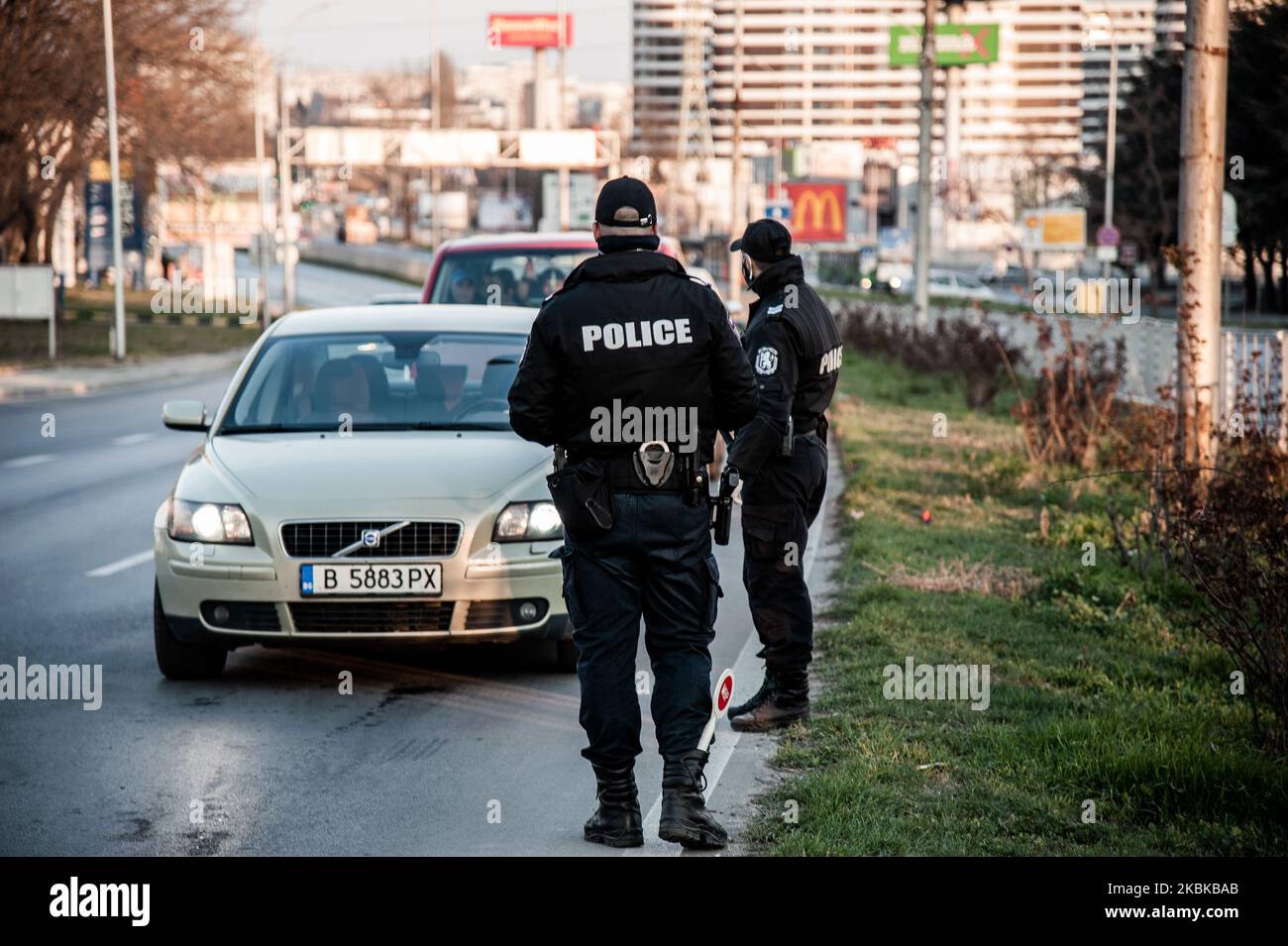 Les policiers munis de masques de protection vérifient les documents ...