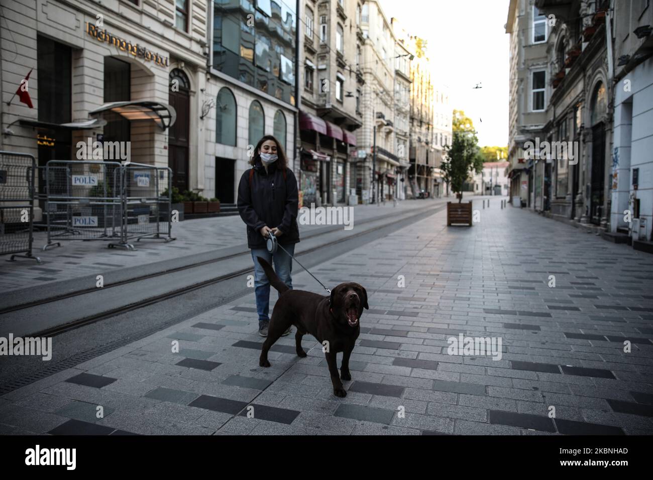 Une femme marche avec son chien sur la rue Istiklal déserte pendant le ...