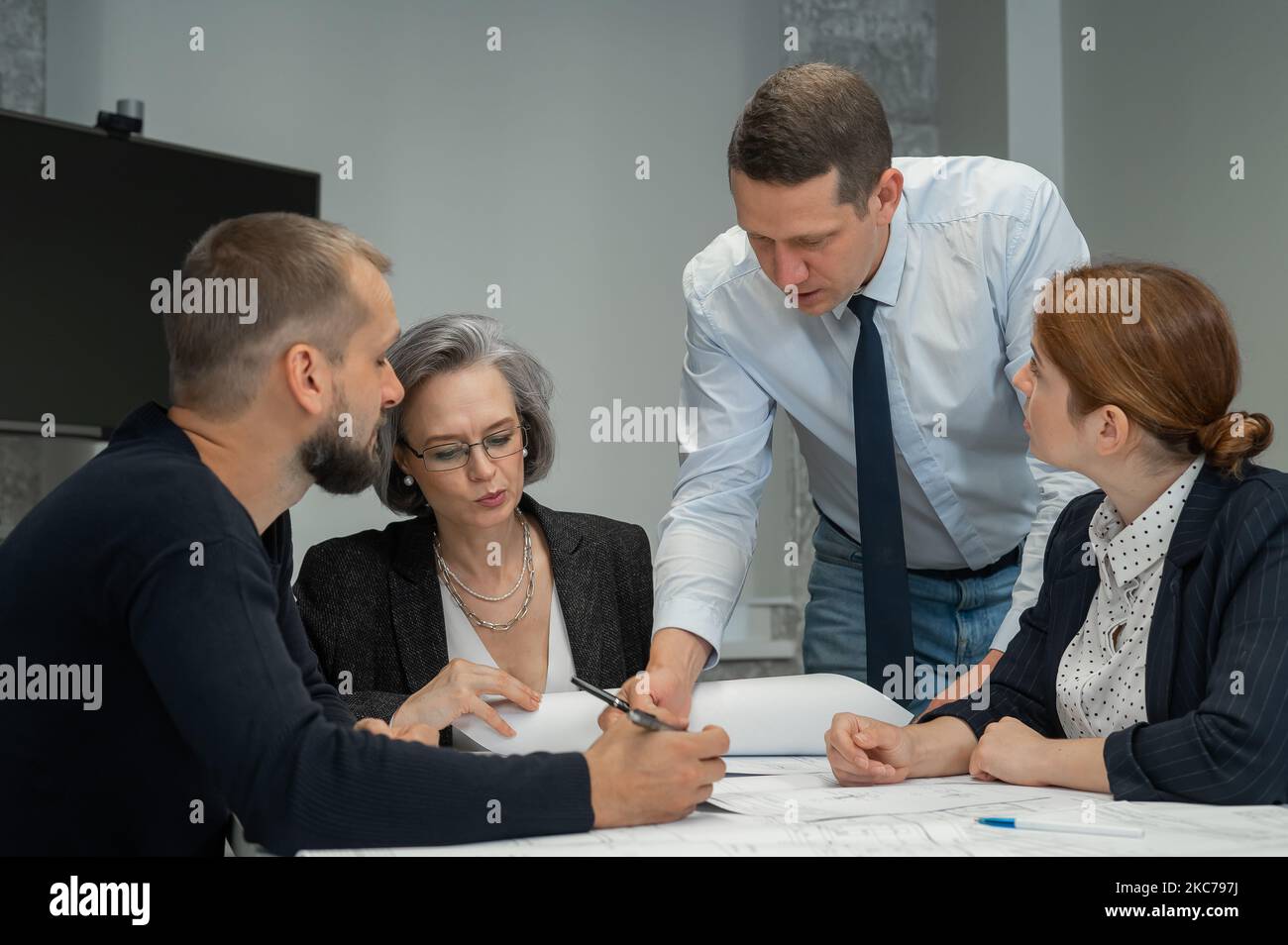 Le patron donne des instructions à trois employés dans la salle de ...