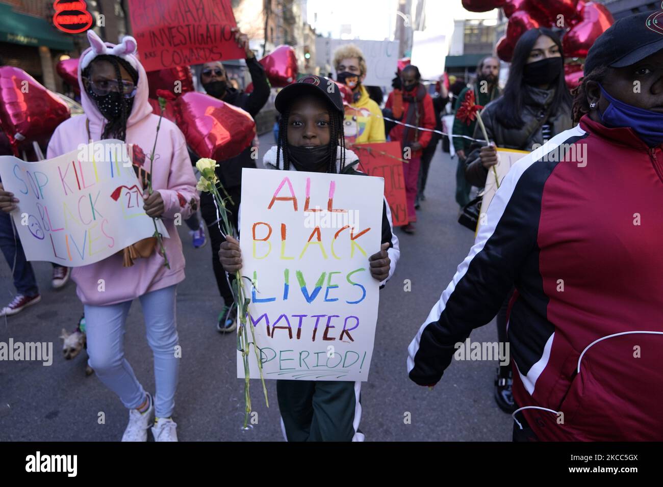 Les gens marchent dans les rues avec des ballons et des placardes vers ...