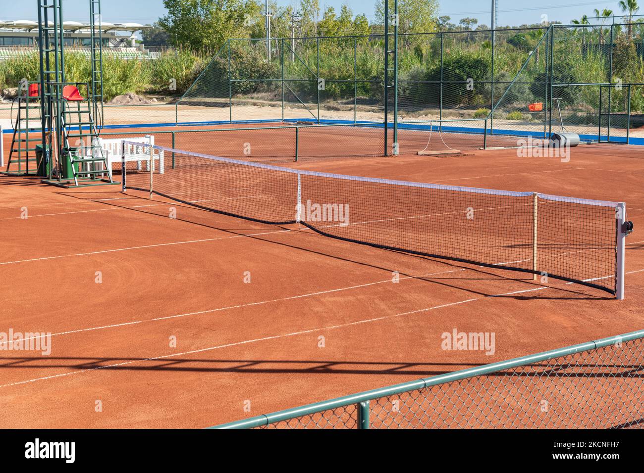 Ligne de base et filet d'un court de tennis en terre battue vide par ...