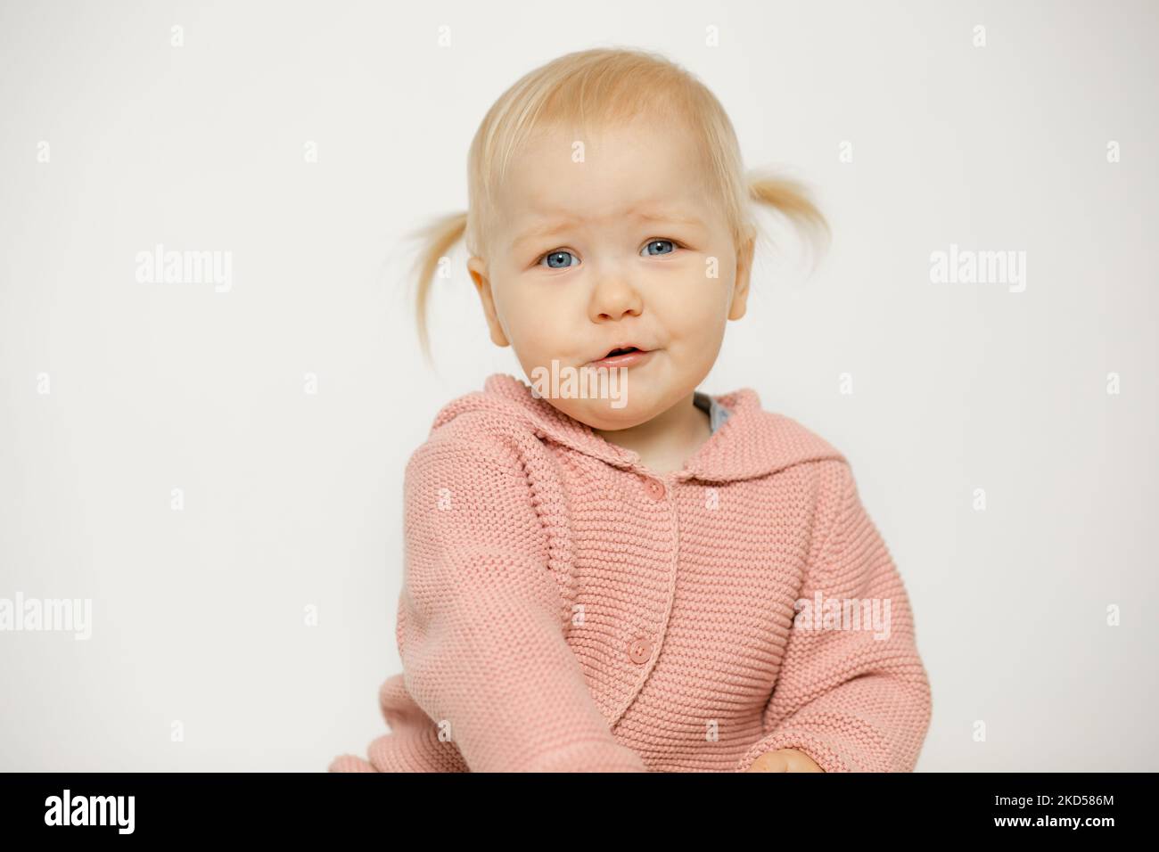 Petite fille malheureuse isolée sur blanc. Portrait d'un enfant triste en studio. Enfant blond ...