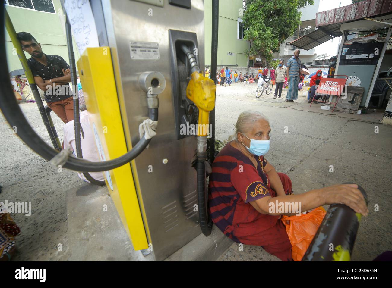 Les Sri Lankais qui portent des masques faciaux sont assis et attendent ...