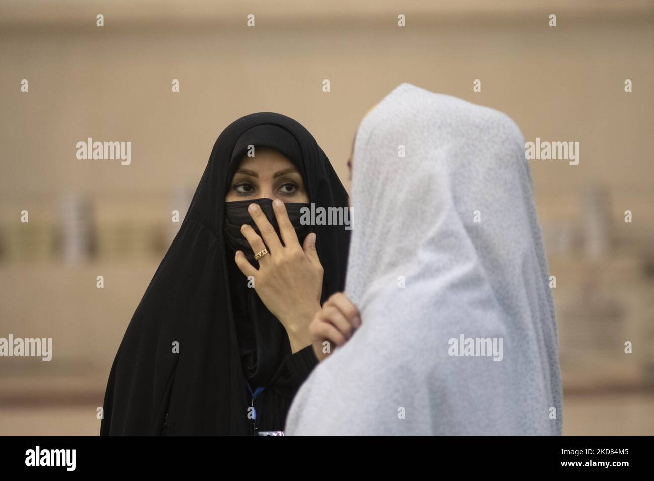 Deux femmes iraniennes voilées se parlent dans une salle de prière de ...