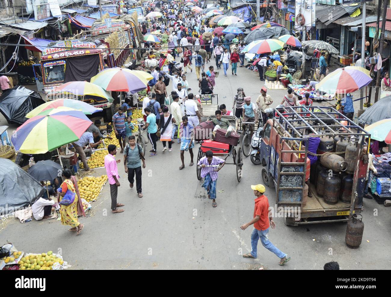 Un arrache-pousse passe devant un marché de gros à Kolkata, en Inde, le ...