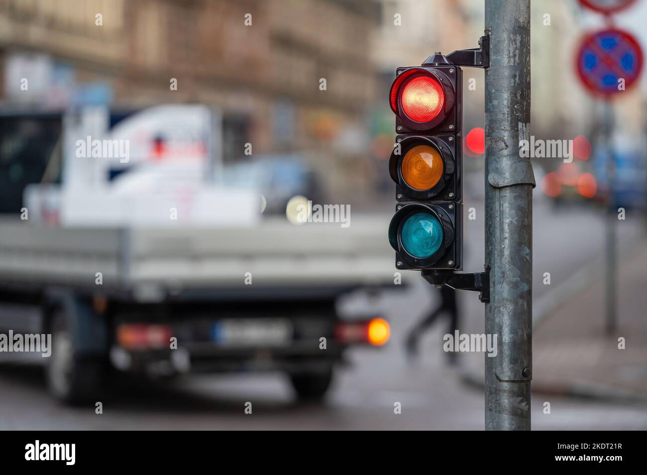 vue floue de la circulation urbaine avec les feux de signalisation, au premier plan un sémaphore ...