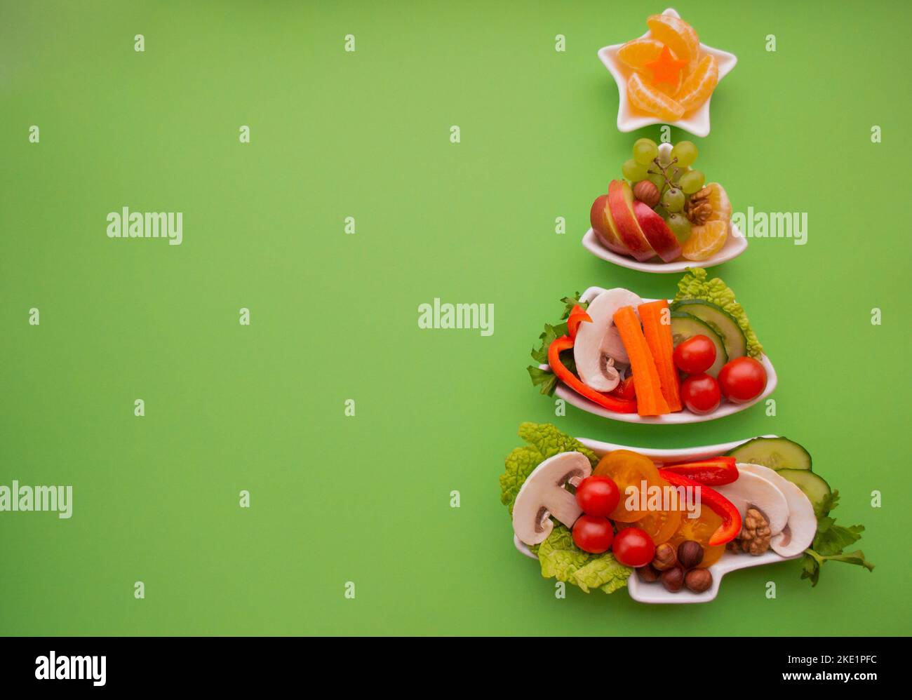 Assiette en forme d'arbre de Noël avec légumes, fruits, champignons et ...