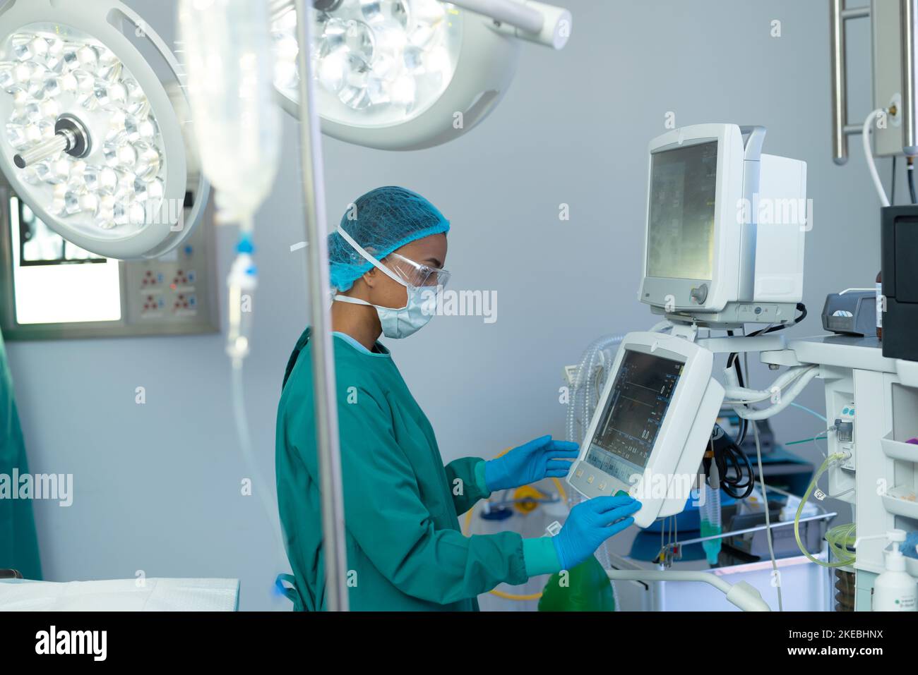 Vue latérale de la femme chirurgien biracial qui utilise de l ...