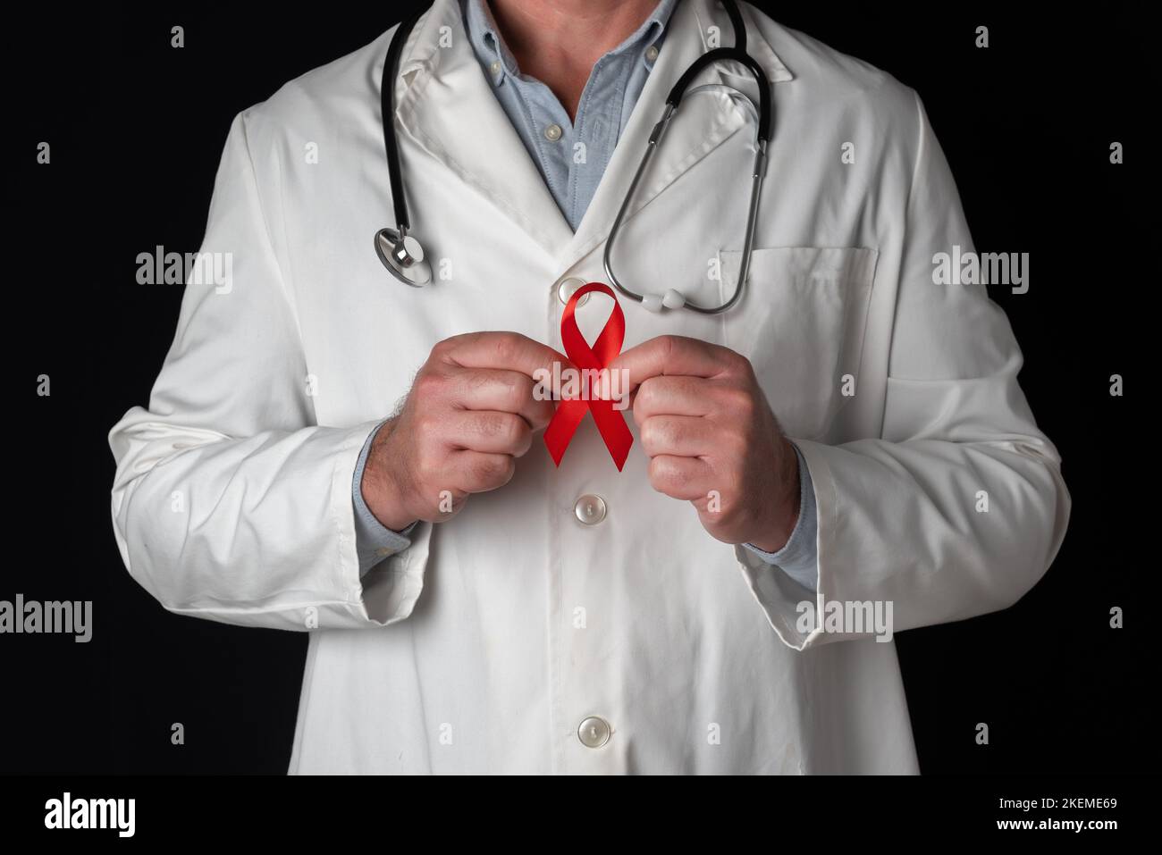 Le médecin tient un ruban rouge avec les deux mains, symbole de la ...