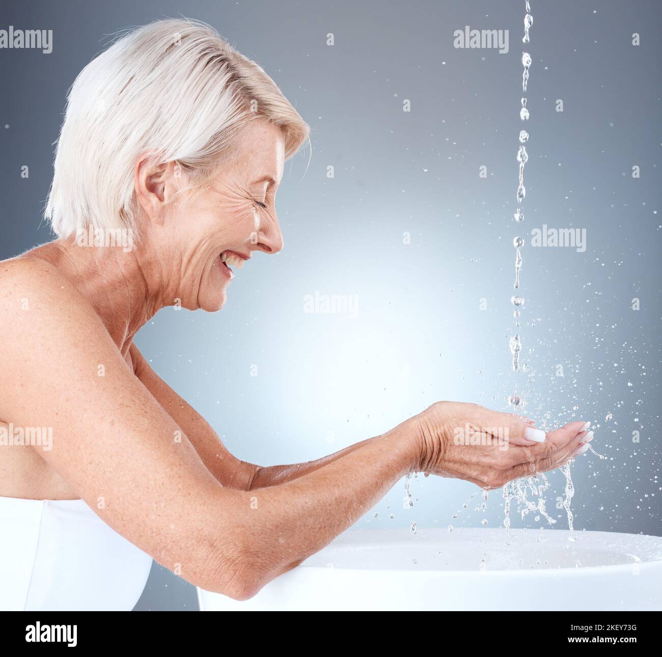 Femme sénior, éclaboussures d'eau et mains de nettoyage dans un bassin ...