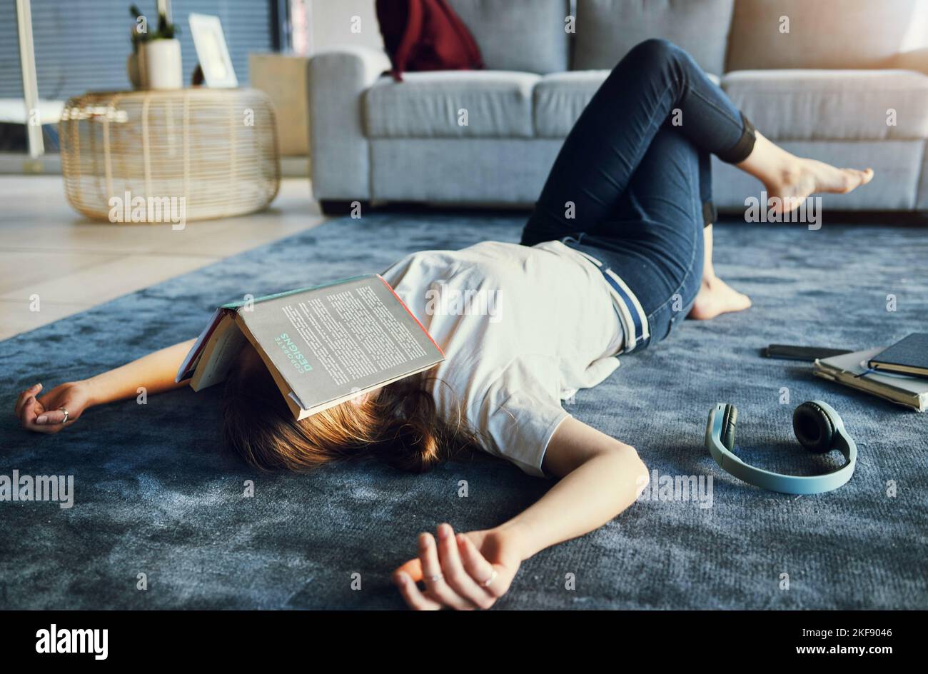 Éducation, fatiguée et livre avec une femme étudiante couché sur le ...