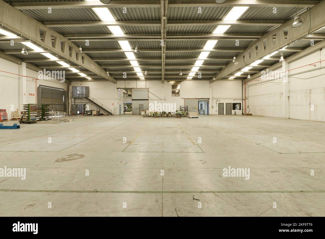 Un grand entrepôt industriel vide avec des planchers en béton et des ...