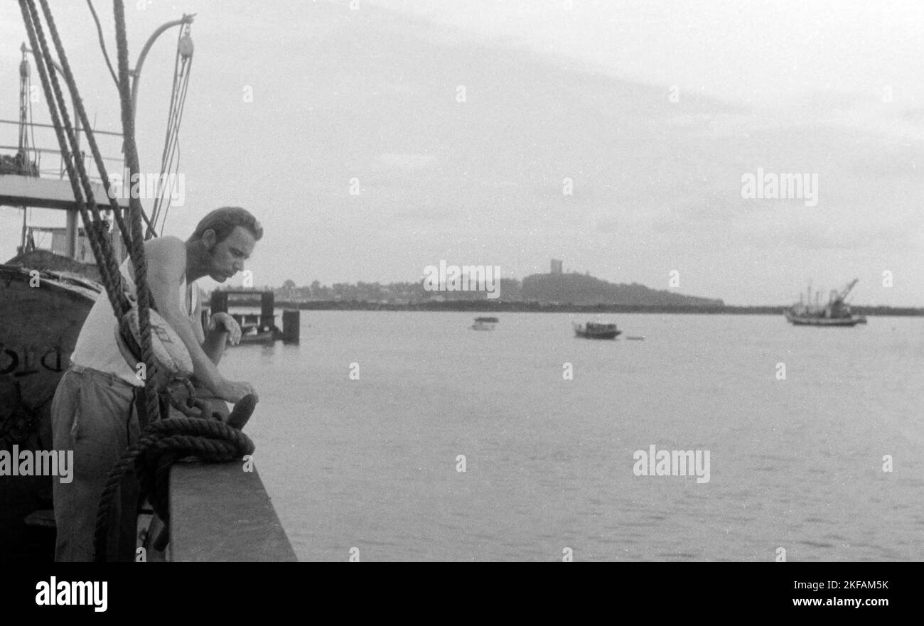 Junger Mann an der Schiffsreling im Hafenbecken von Sekondi-Takoradi ...