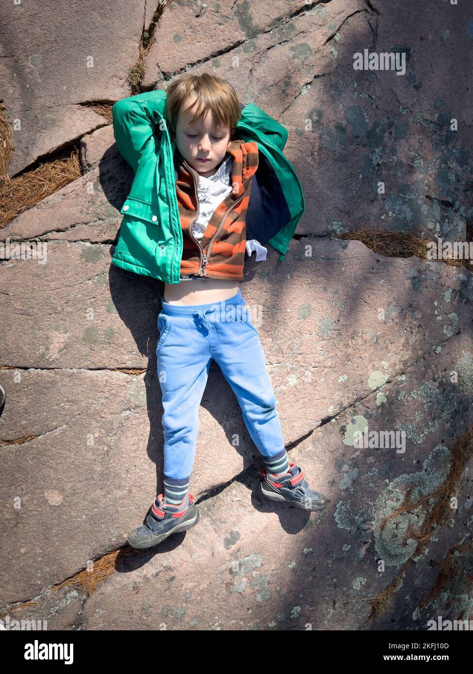 Vue en grand angle d'un adorable garçon bien pensé, les mains derrière ...