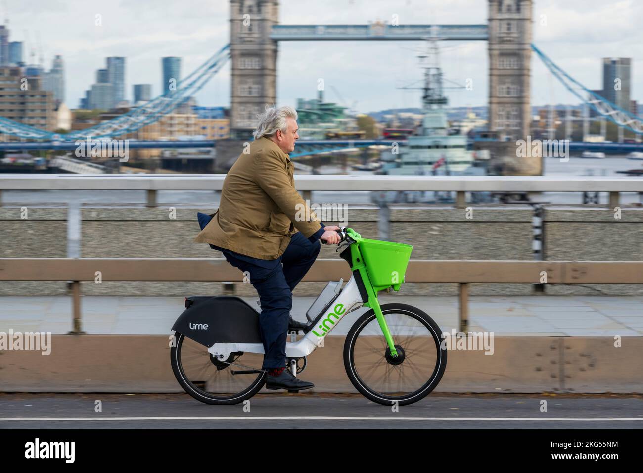 Un homme qui fait la navette à bord d'un vélo électrique Lime à travers ...