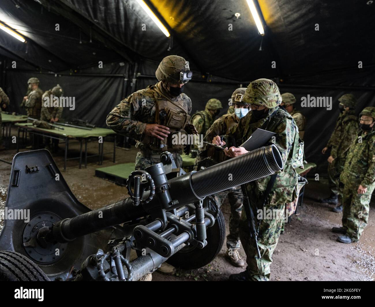 Des Marines des États-Unis et un soldat de la Force d'autodéfense au sol du Japon inspectent un ...