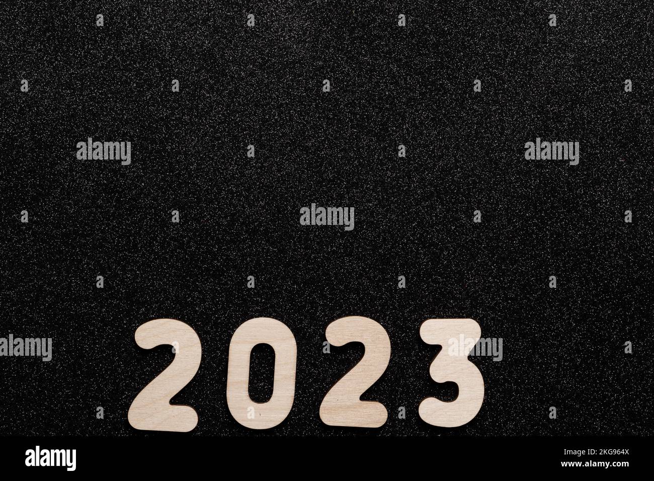 Carte du nouvel an 2023. Chiffres en bois de l'année sur un fond noir éclatant et étoilé. Modèle ...