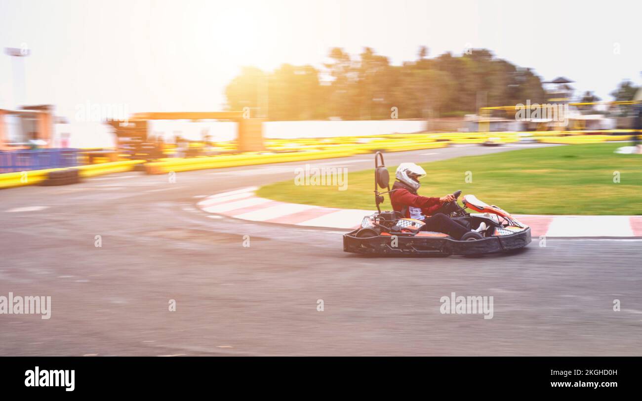 Un conducteur en train de conduire et un casque conduit une voiture de course. Courses de karts ...