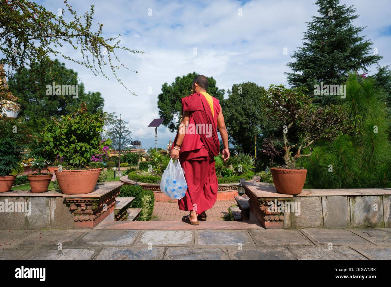 Un moine transportant des bouteilles d'eau dans la cour du monastère ...