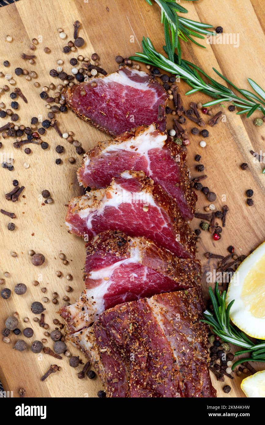 viande séchée et épicée tranchée sur une planche de bois, épices ...