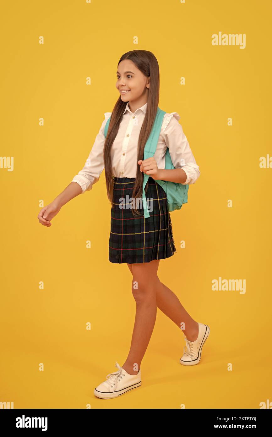 enfant heureux avec sac à dos dans l'uniforme de l'école pleine longueur se déplacer dans le ...
