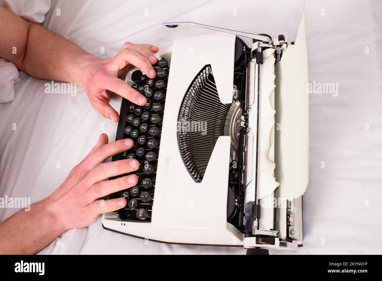 Mains écrivain lit blanc linge de lit travail sur le nouveau livre ...
