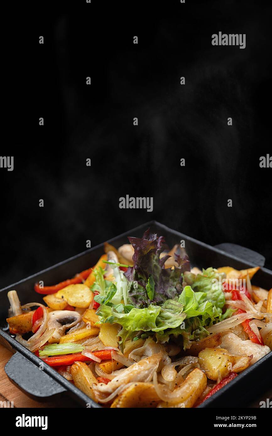 Poêlée de pommes de terre avec légumes et champignons dans une poêle en ...