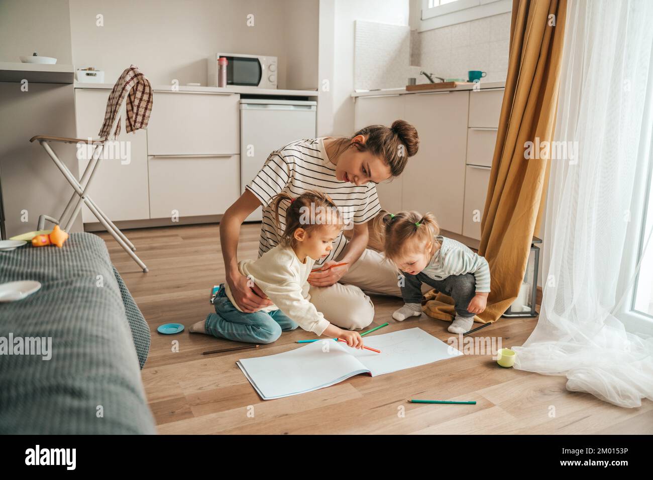 Une petite fille griffonne avec un crayon de couleur dans le carnet à ...