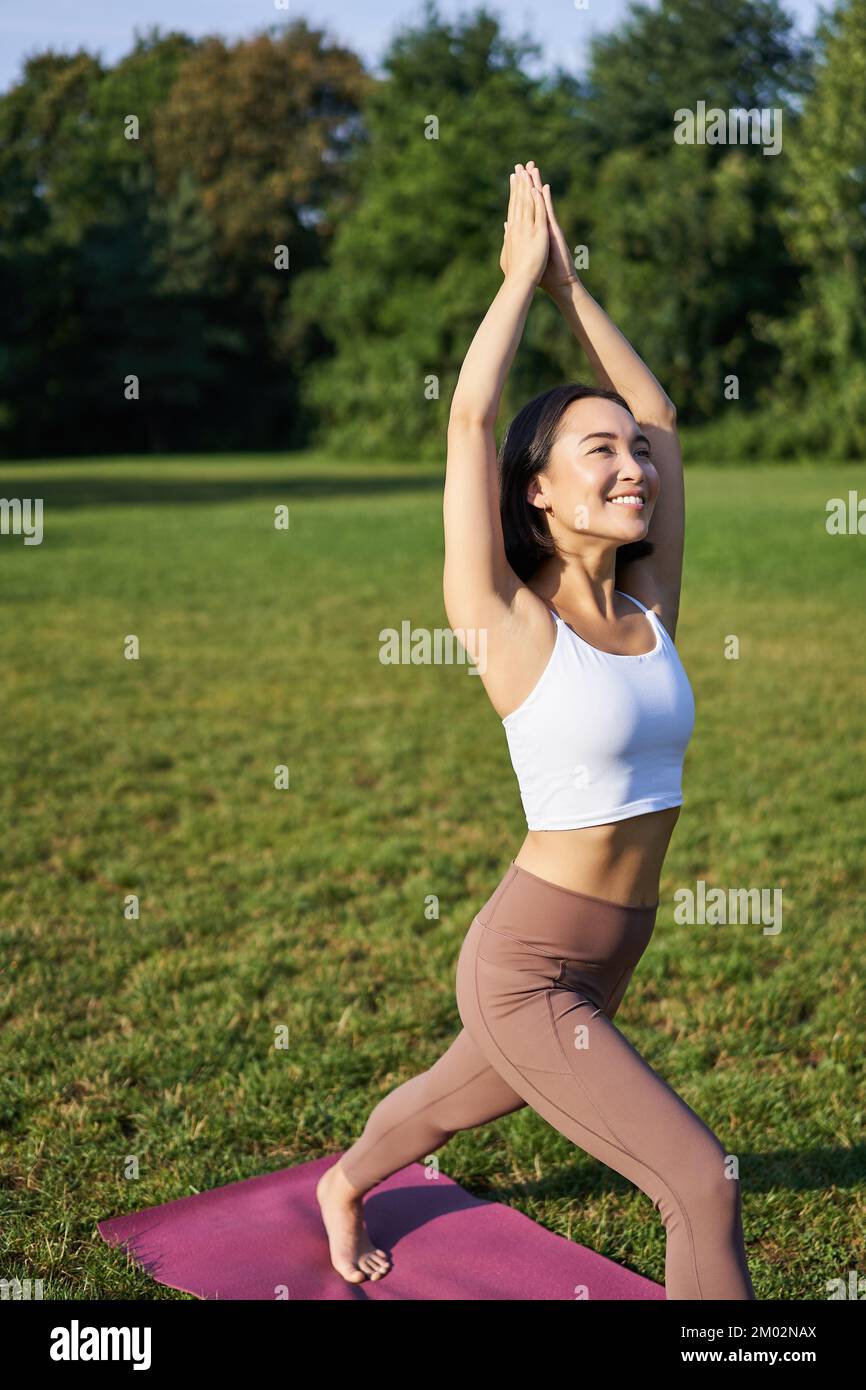 Plan vertical de la jeune fille asiatique de forme physique faisant le yoga asana, debout dans ...