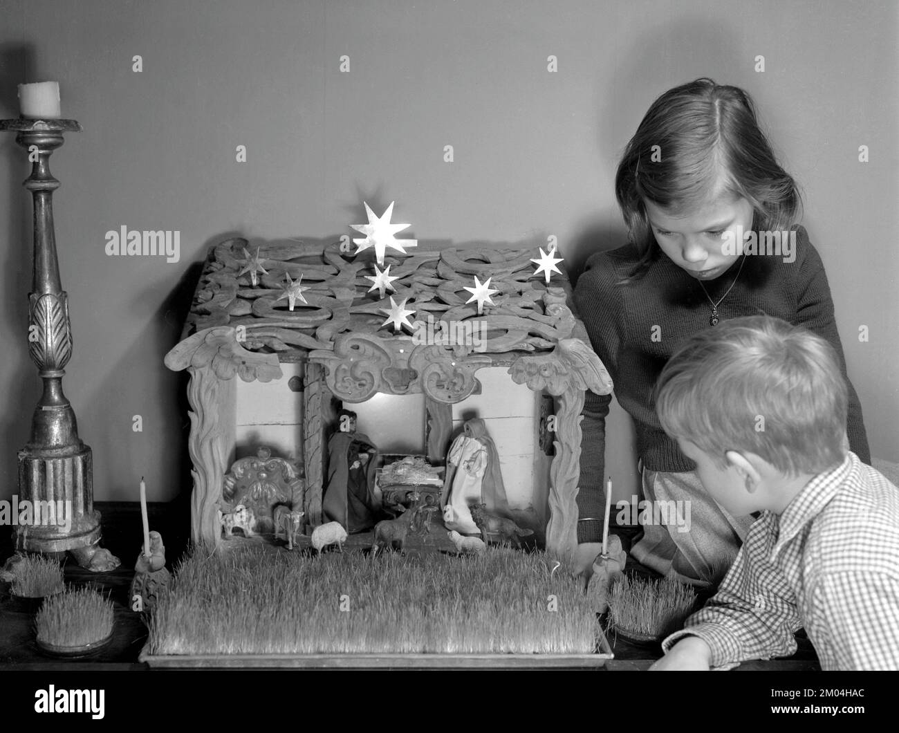 Noël en 1950s. Deux enfants avec une scène de la nativité, le bébé ...