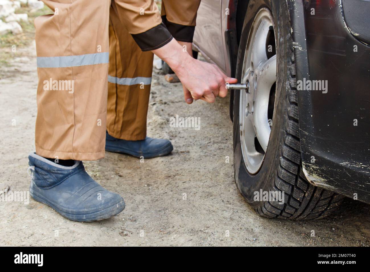 Auto mécanicien homme avec un tournevis électrique changer le pneu à l'extérieur. Service de ...