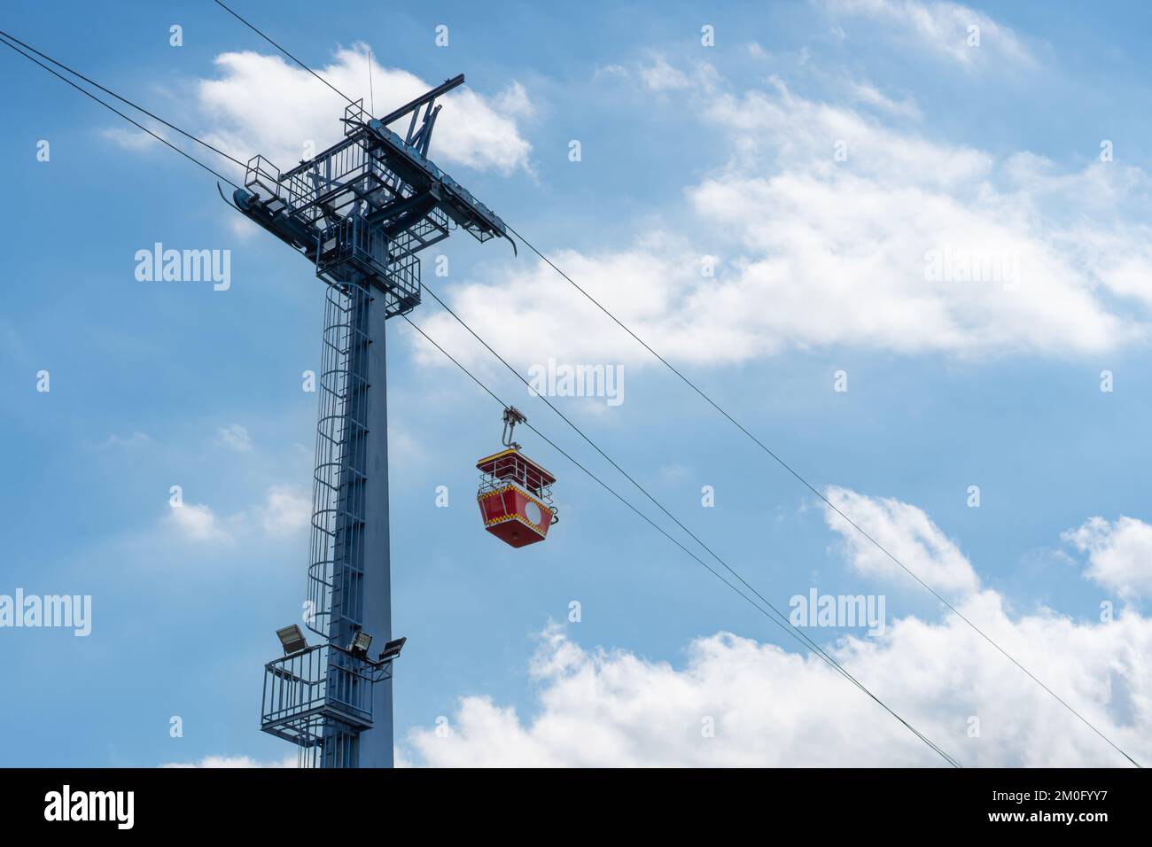 Le téléphérique rouge flotte sur une élingue pour le transport par les ...
