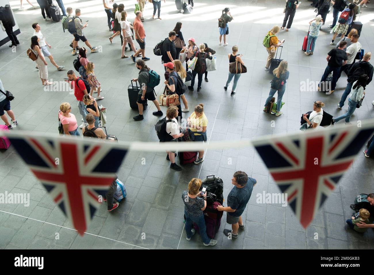 Les voyageurs munis de valises sont vus derrière un Union Jack qui fait ...