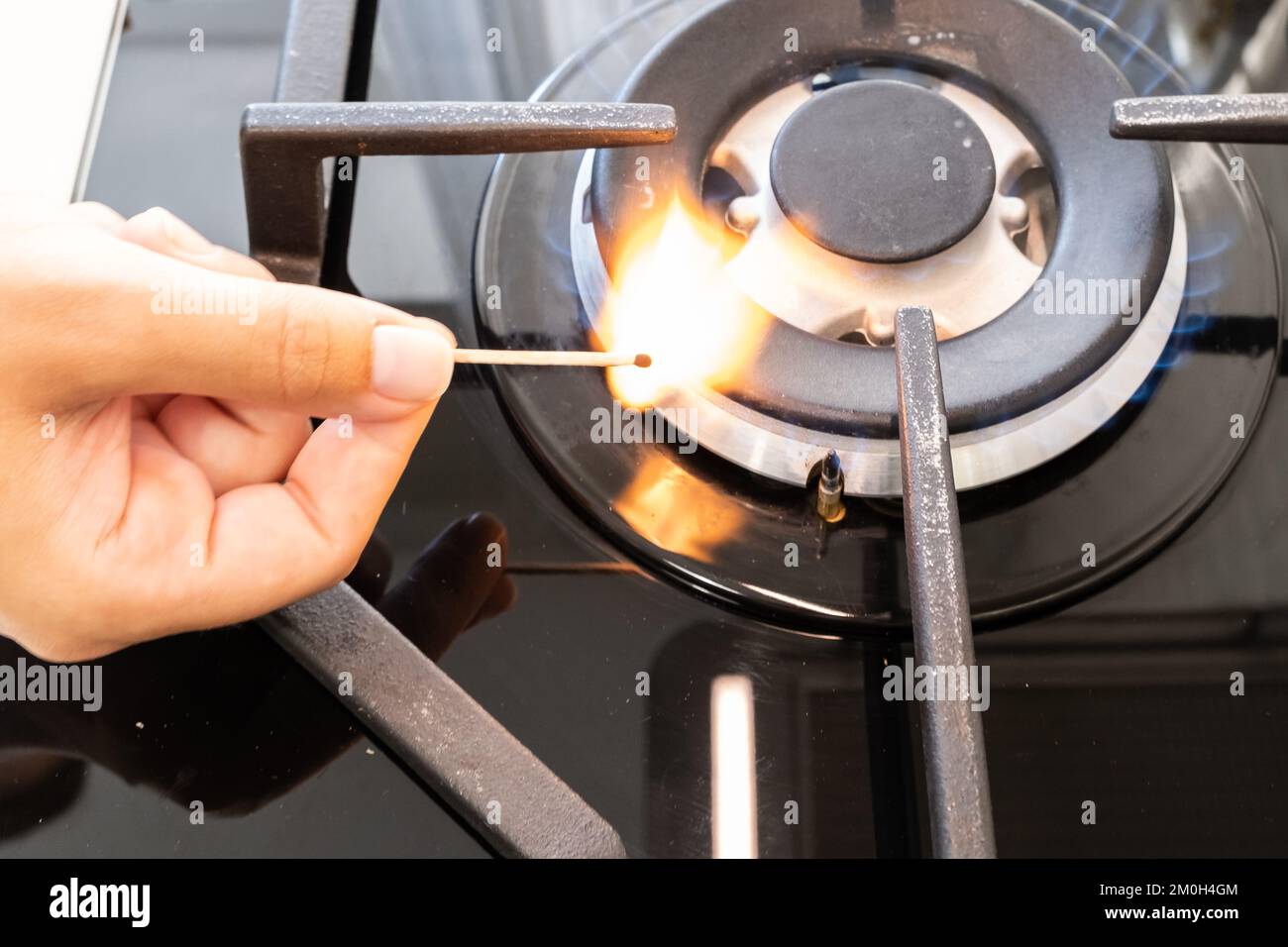 La main allume le brûleur à gaz sur le poêle à gaz Photo Stock - Alamy