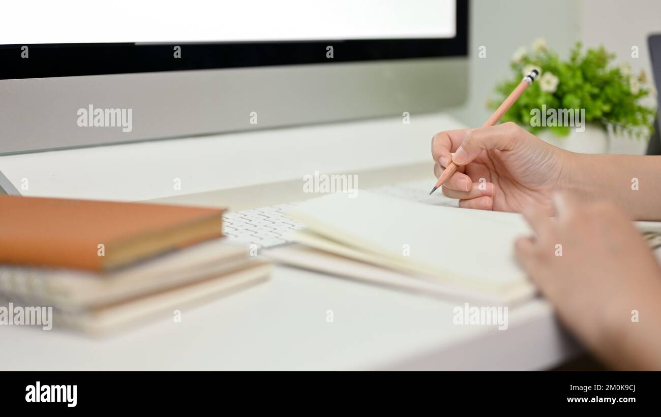 Une femme qui écrit sur son carnet, prend des notes ou inscrit quelque ...