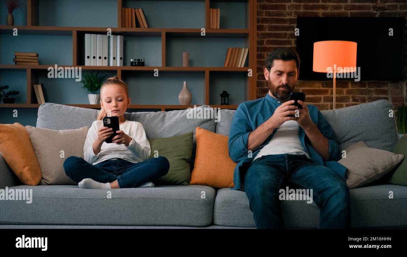 Ennuyé enfant fille se reposant à la maison avec le père jeune père ...