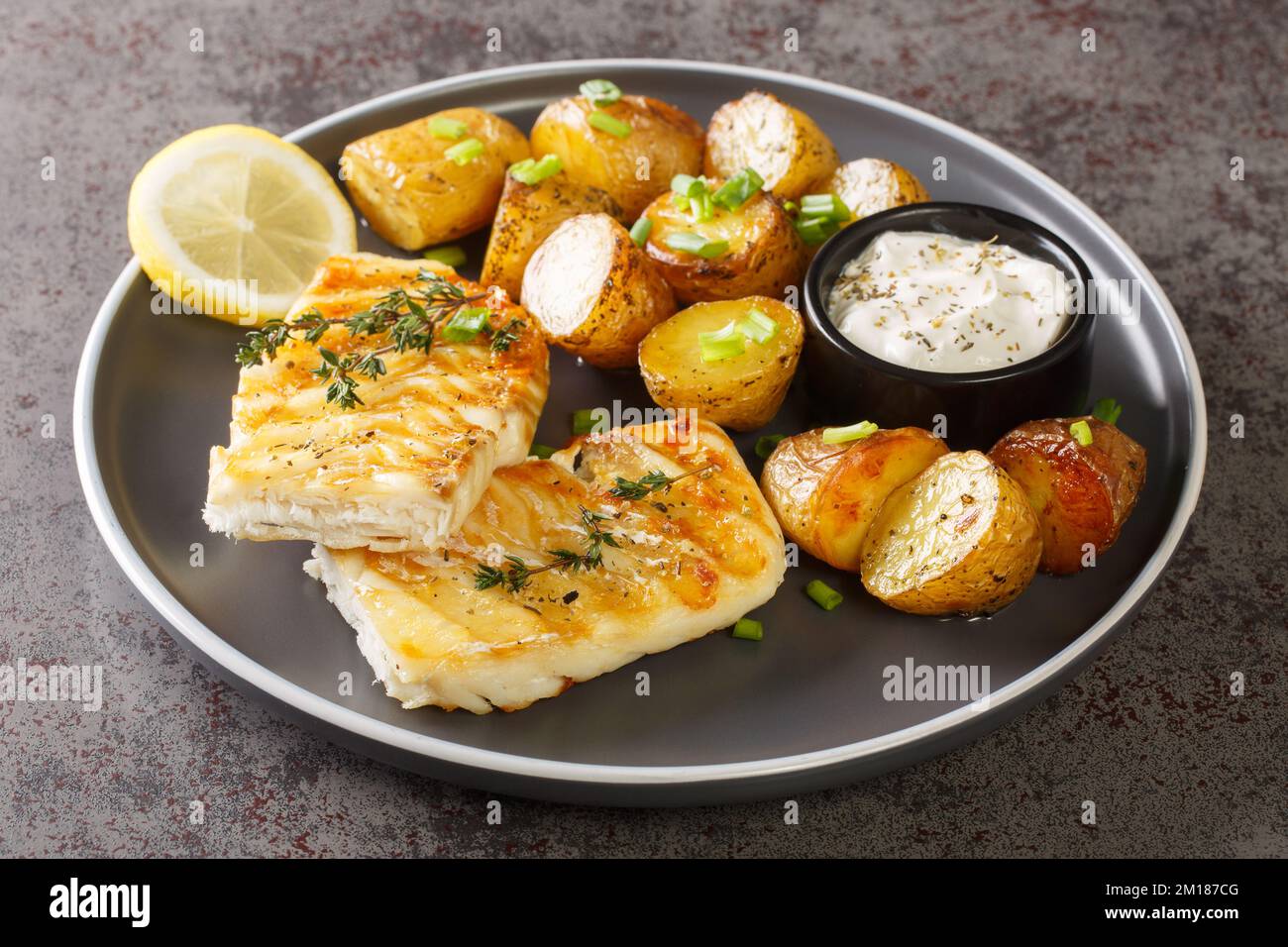 Filet de morue grillé au thym servi avec des pommes de terre au four ...