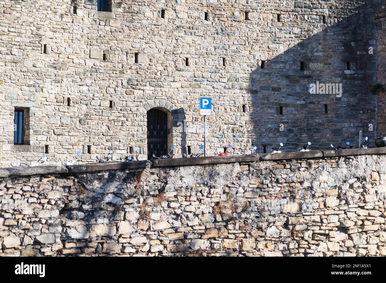 Un bâtiment blanc sur une rue de Bergame avec de nombreux miroirs de ...