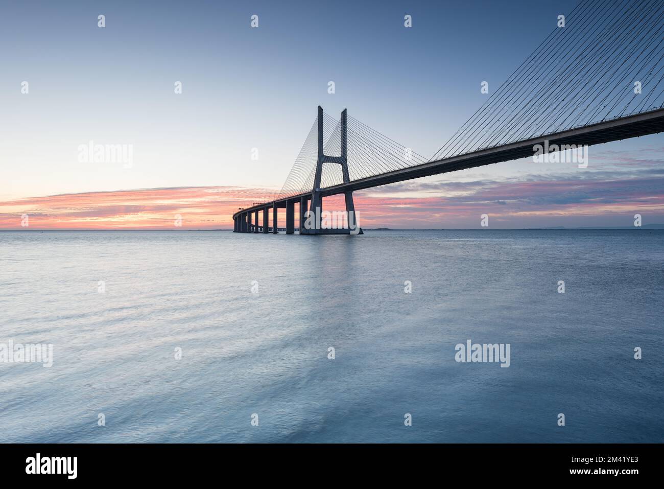 Arrière-plan avec lever de soleil coloré sur le pont de Lisbonne. Le ...