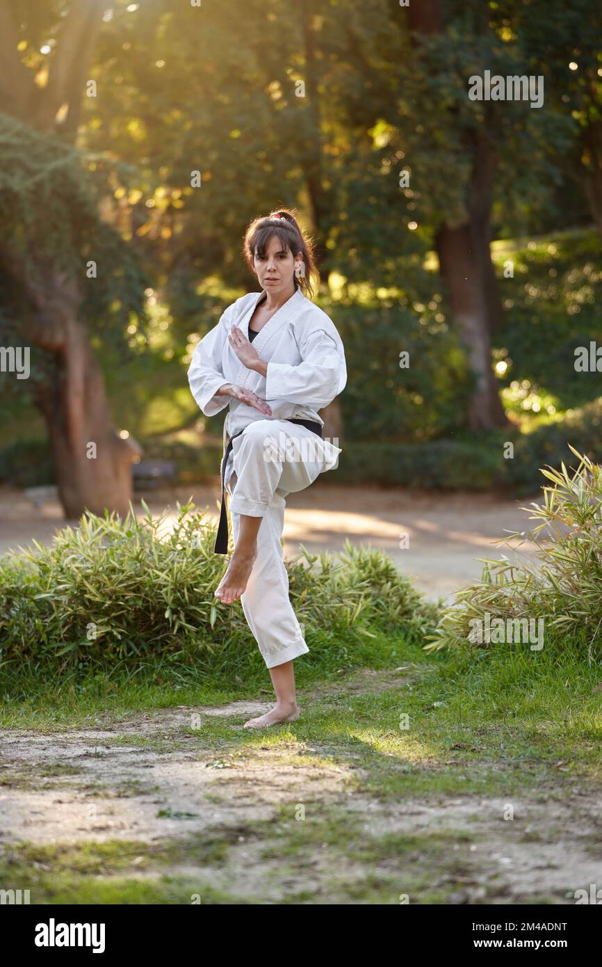 Femme en kimono debout dans la posture de karaté tout en faisant de l ...