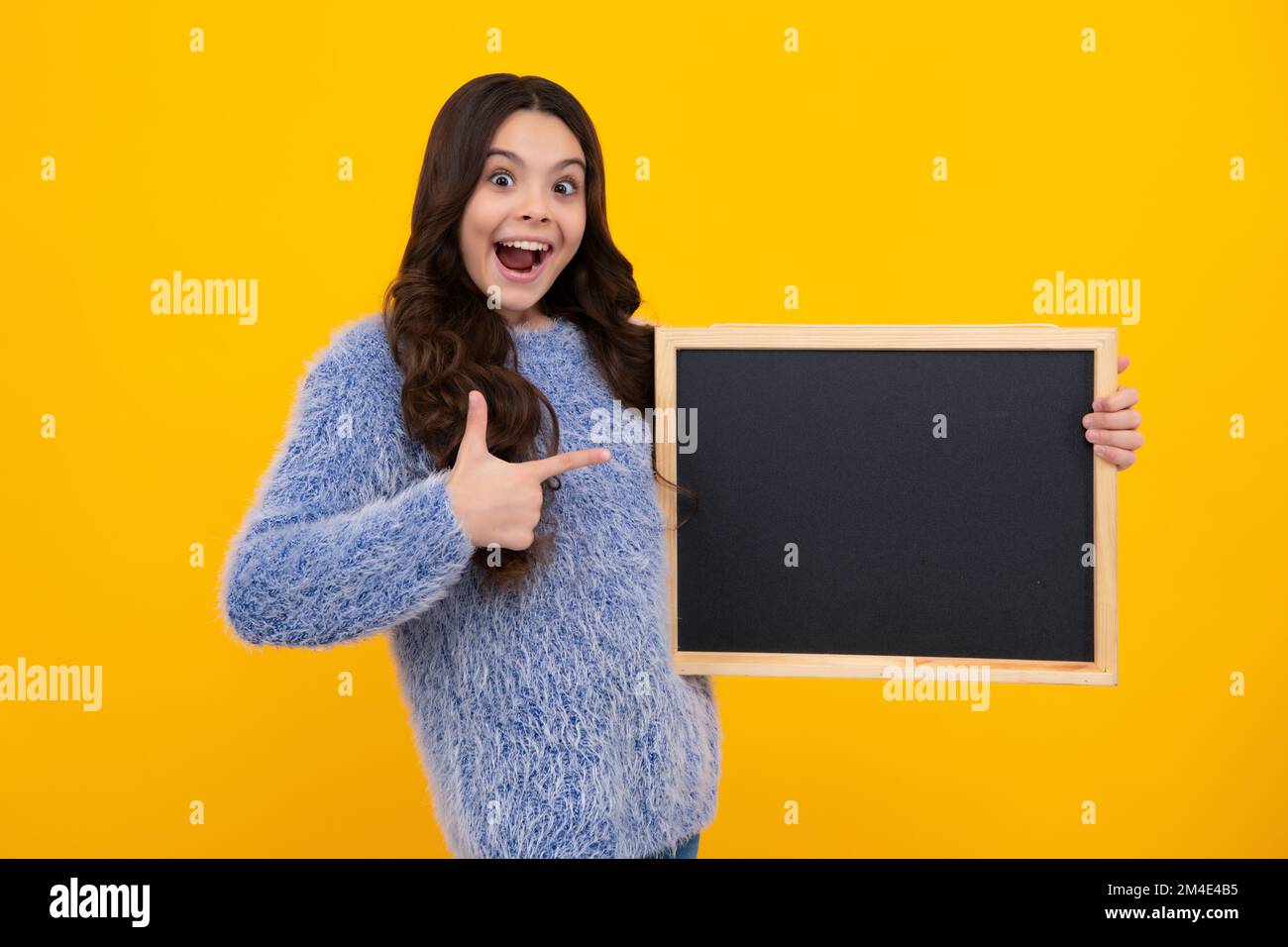 Adolescent tenant un tableau noir vierge pour le message isolé sur fond ...