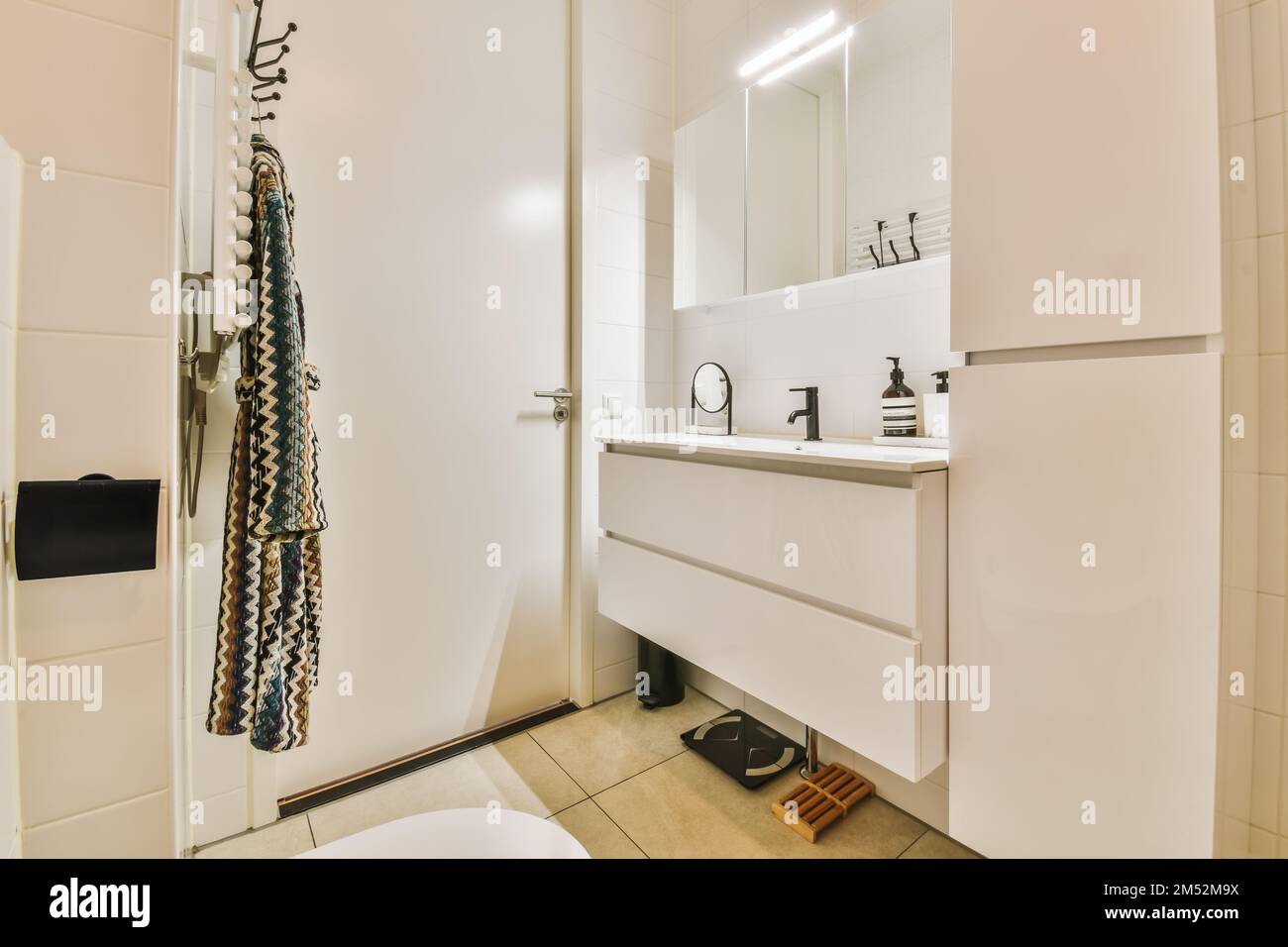 une salle de bains avec toilettes, miroir et serviette accrochée au mur ...