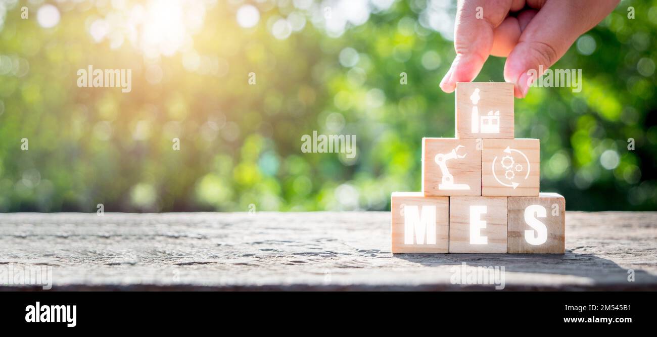 Mes - Manufacturing Execution System concept, Man Hand tenant un bloc de cube en bois avec l ...