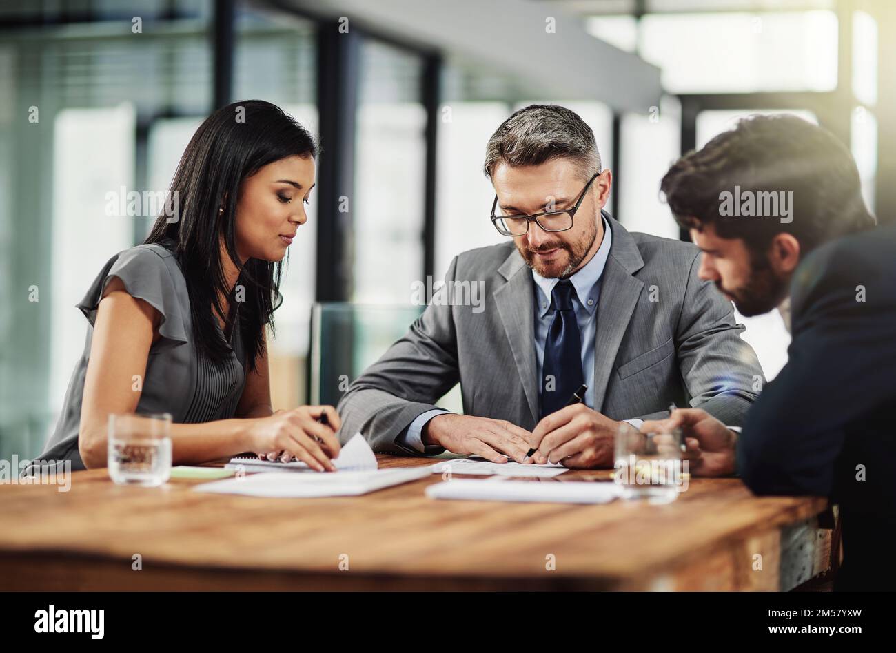Autour de la table de réunion. trois collègues assis autour d'une ...