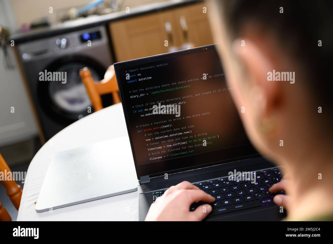 Encodage dans la maison, une femme écrivant le code sur un ordinateur ...
