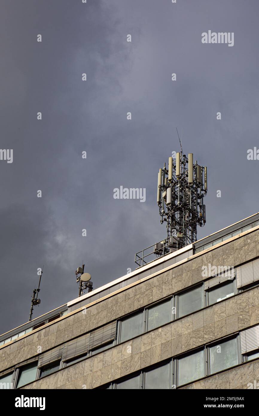 Différents mâts de téléphones cellulaires dans un bâtiment devant un ...