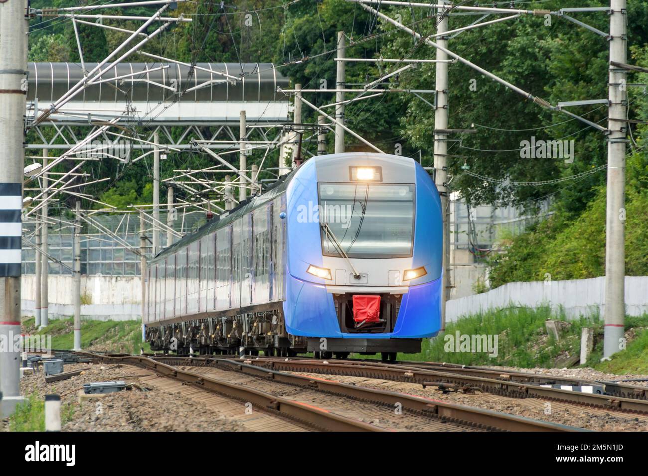 Le train électrique de banlieue de couleur bleue va d'une certaine ...